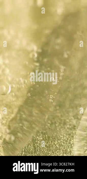 Vertical video. Oil bubble swirl. Fluid gas texture. Defocused golden ...