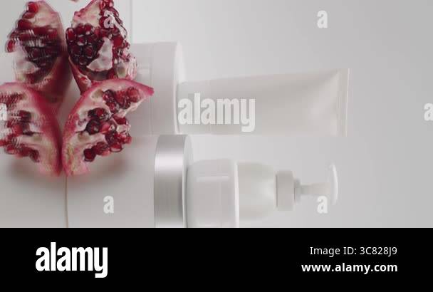 White Bottle with pomegranate fruits for cosmetics on a white ...