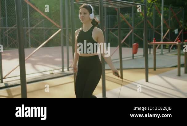 Fit woman doing cardio and skipping in a park. Slow motion. Sport ...