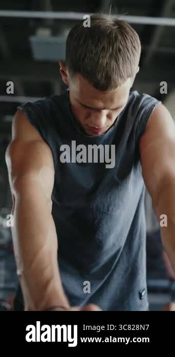 Intense close-up portrait of a confident young man in a gym setting ...
