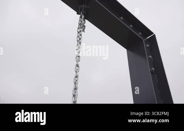Iron beam with secured chain serves as part of street workout machine ...