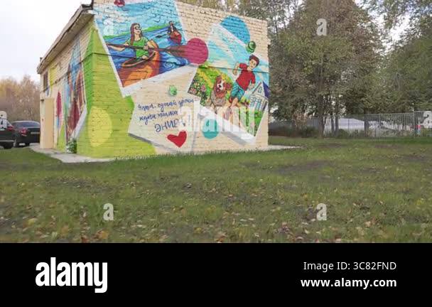 Building exterior wall adorned with colorful mural depicting activities ...