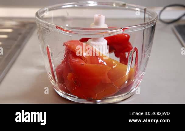 Close-up video of preparing red bell pepper pesto in a chopper. The ...