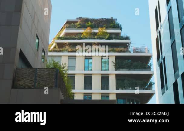 Contemporary building with greenery covered terraces with modern urban ...