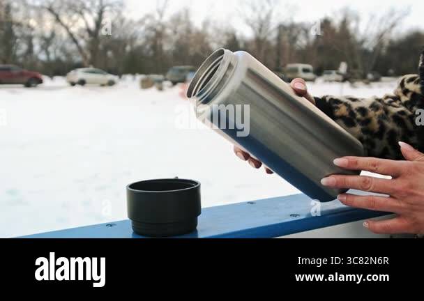 Woman hands pouring hot coffee from a thermos bottle into a mug. Hot ...