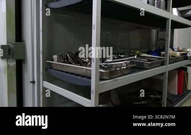 Industrial kitchen utensils arranged on shelves in a commercial ...