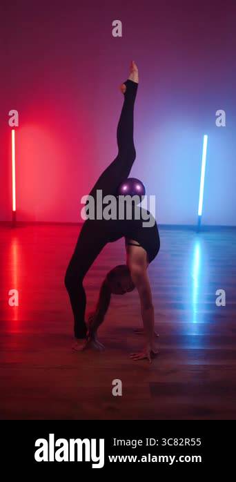 Woman performs rhythmic gymnastics with a ball in a vibrant studio setting Stock Video Footage ...