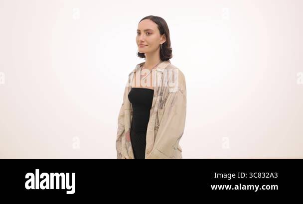Stylish woman smiles as remembers joyful day from past against white ...