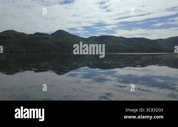 Mirroring surrounding hills and expansive sky, lake fimon radiates ...