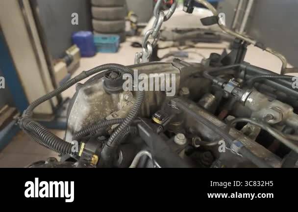 Heavy-duty metal chain suspending car engine during precision ...