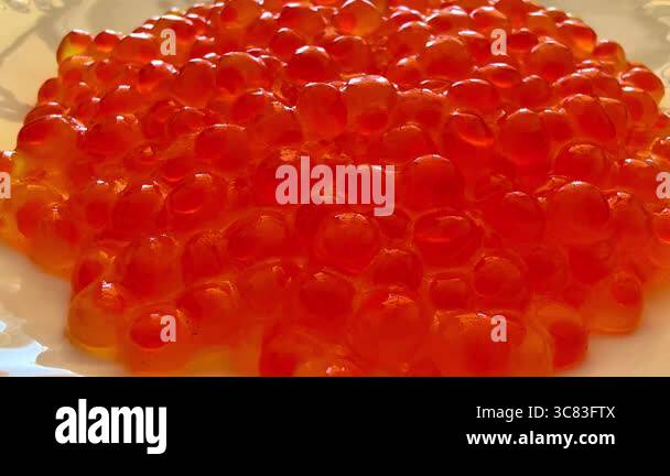 Fresh red fish roe beautifully displayed on a decorative plate, making ...