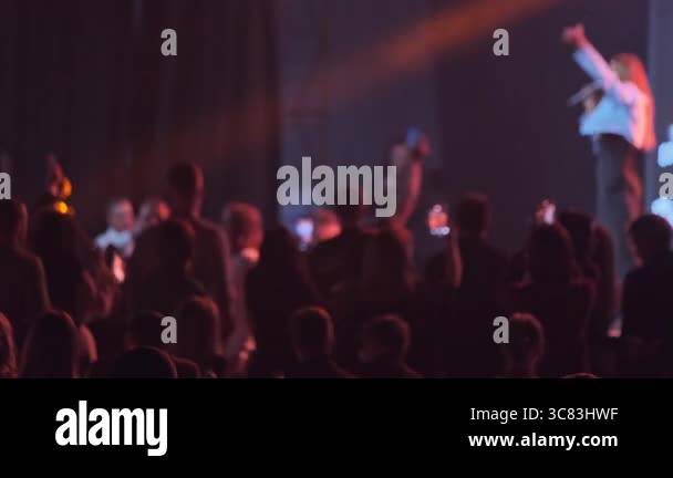 Singer performing with microphone in nightclub stage while audience ...