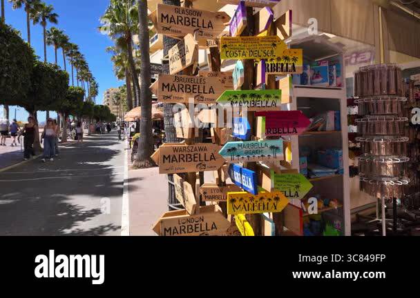 Many colorful wooden direction signs pointing to Marbella from ...