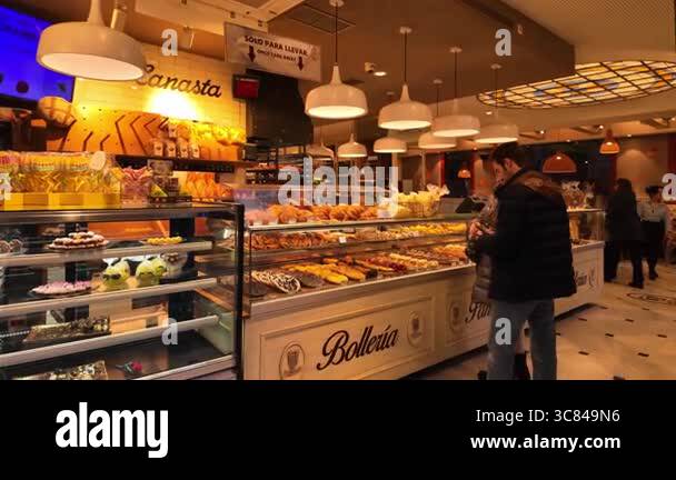 Tourists buying cakes and bread in a traditional spanish bakery in ...