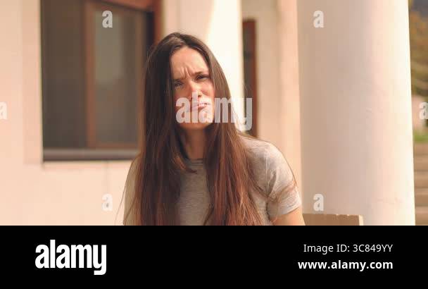Smiling attractive brunette woman looking at camera listening to ...