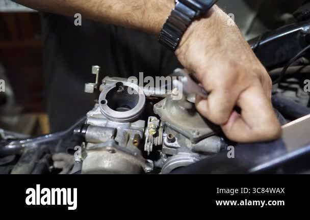Male hands of repairer fixing motor of motorbike using tool at ...