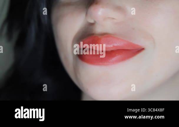Macro shot of female lips with healed permanent makeup in warm red ...