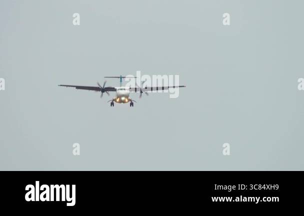 Turboprop aircraft flying in cloudy weather with landing gear extended ...