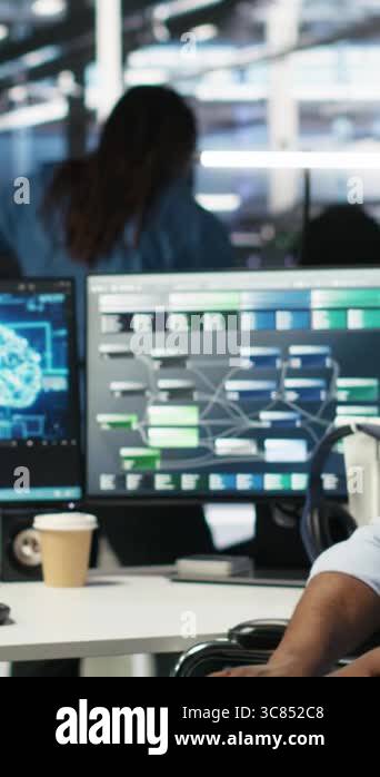 Vertical video Technician in wheelchair and data center manager using AI node tree software to ...