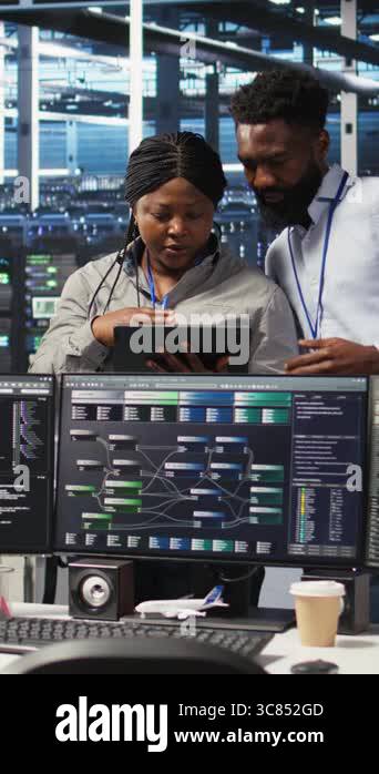 Vertical video Smiling server hub engineers collaborating, using AI algorithms and node tree ...