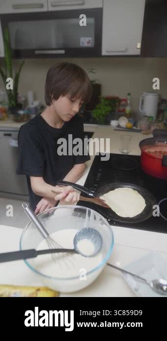 A child is joyfully cooking pancakes in a beautifully stylish kitchen ...
