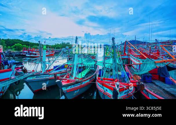 Time lapse of colorful fishing boats parked at the dock under a ...