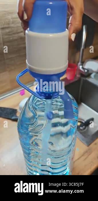Womans hands assembling a manual water pump dispenser on a big plastic ...