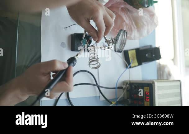 Vertical cropped shot of hands of unrecognizable person soldering ...
