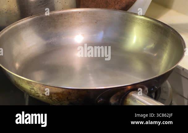 A captivating sequence of water being poured into a frying pan ...
