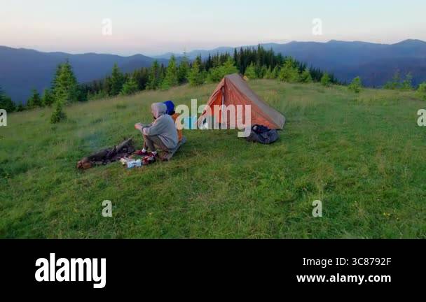 Aerial view of morning camping. Campsite at sunset with yellow tent ...