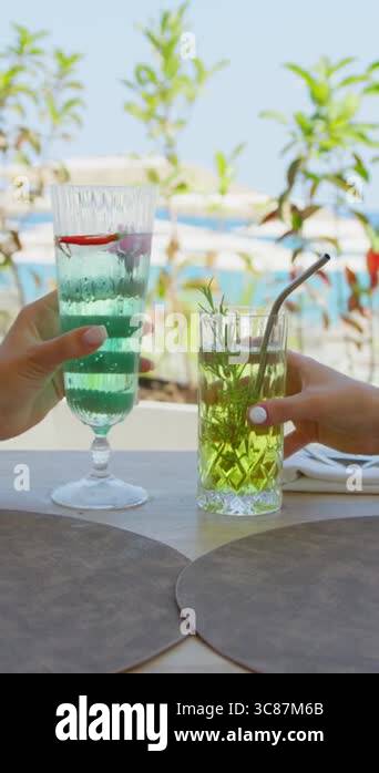 Two Friends Cheering With Colorful Cocktails At The Beach Resort During ...