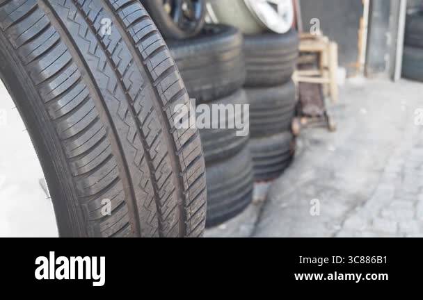 Tires are stacked outside a shop, showcasing different types Stock ...