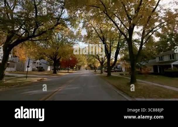 POV wide shot of suburban street in neighborhood on a beautiful bright ...