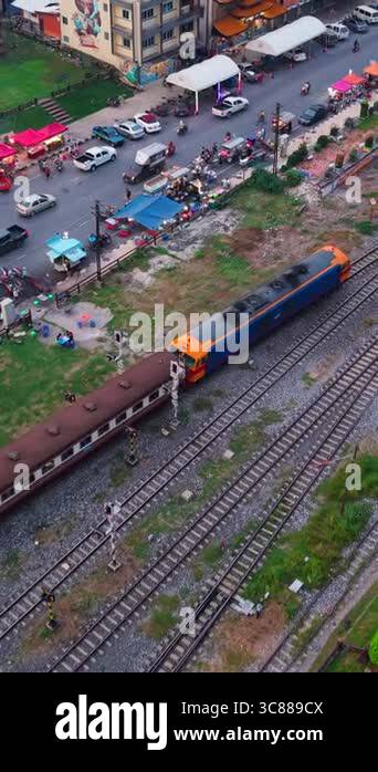 Aerial view of a train passing by the market crossing the city in ...