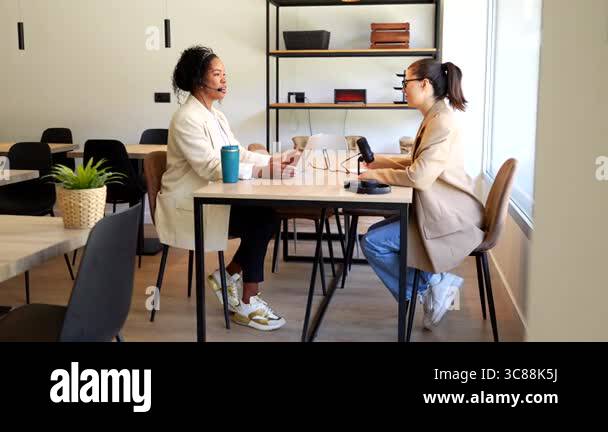 Professional female podcasters collaborating, recording audio episode ...