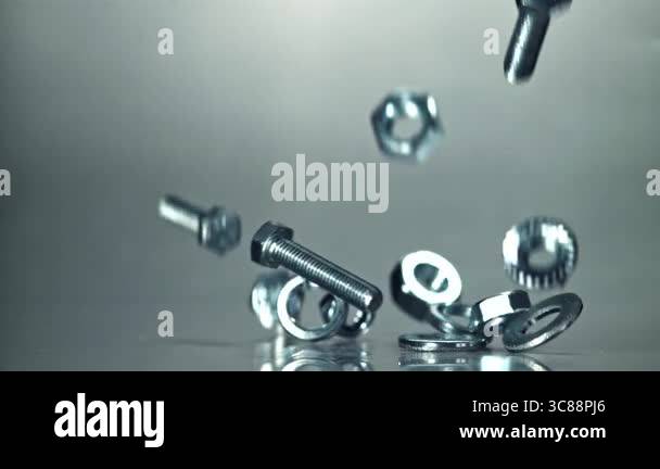 Falling nuts, bolts and washers on a metal table. Filmed on a high ...