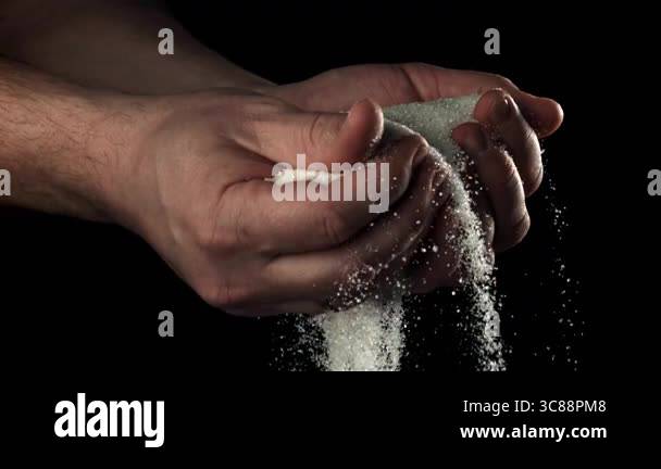 Sugar is pouring out of his hands. Filmed on a high-speed camera at ...