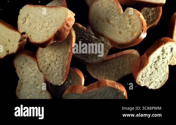 Sliced pieces of bread fly up and fall down. Filmed on a high-speed ...