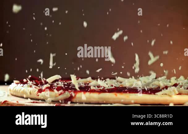 Making pizza. Mozzarella cheese falls on pizza. Filmed on a high-speed ...