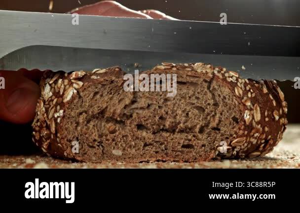 The chef slices fresh bread. Filmed on a high-speed camera at 1000 fps ...