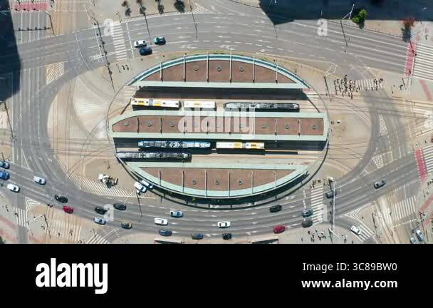 Ascending aerial top view of modern tram terminal at busy roundabout ...