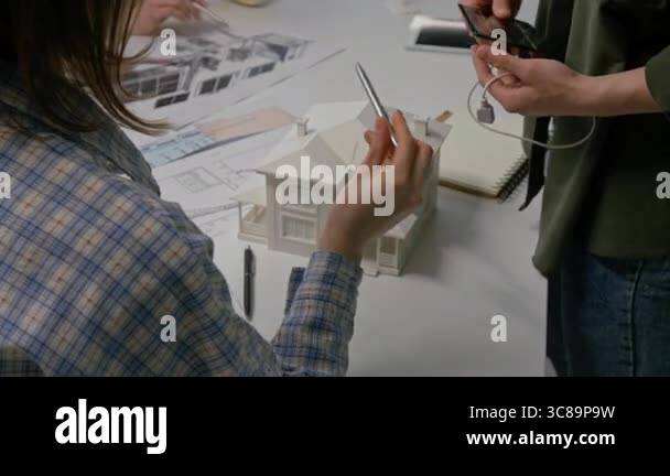 Close-up shot of unrecognizable architects collaboratively working on ...