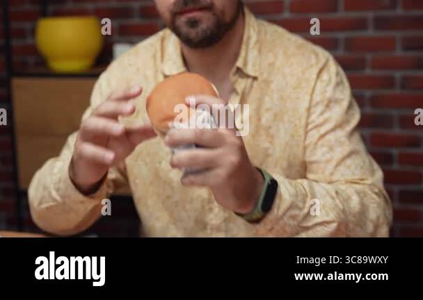 Junk food advertisement concept. Adult stylish bearded man sitting at ...