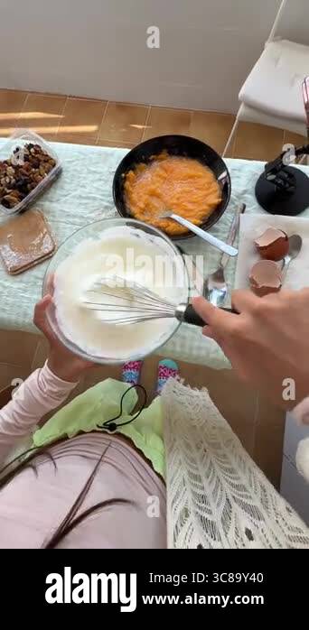 A person skillfully whisking a creamy mixture in a bowl that is ...
