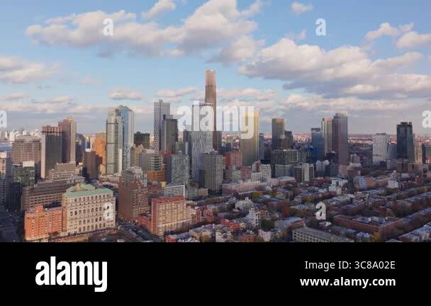 Aerial view capturing Downtown Brooklyn skyline, sunlit autumn day, white clouds hovering over ...