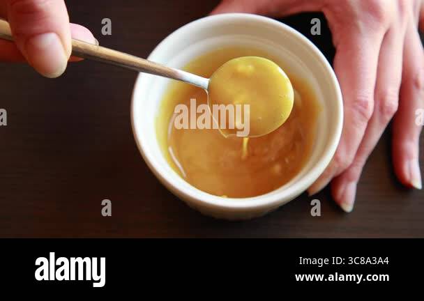 Close-up video of mixing mustard, honey, and garlic in a small bowl ...