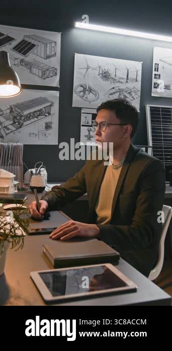 Vertical side shot of male Asian engineer designing sustainable ...