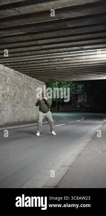 A determined fighter is practicing various boxing moves under a dimly ...