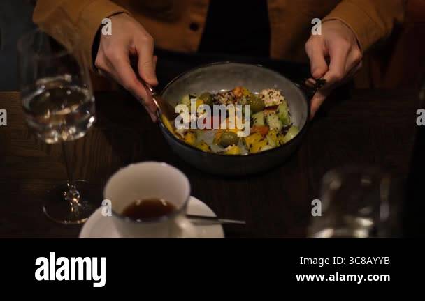 young european man eating vegetable greek salad for dinner in ...