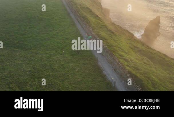 Aerial. Tourists follow the misty road along the cliff of the Moher ...